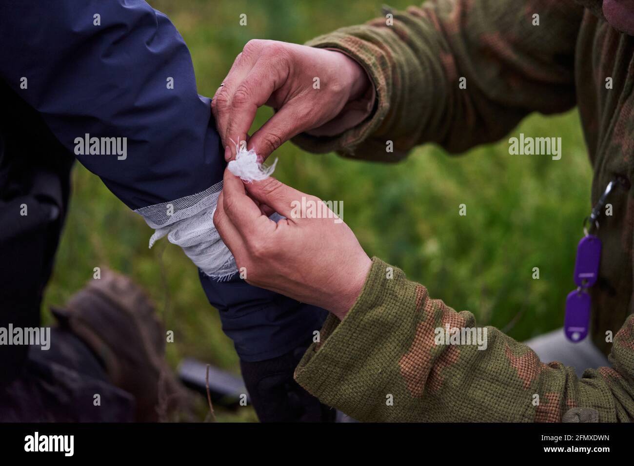 Close-up of a soldier's hand bandaging a wounded soldier's arm Stock ...
