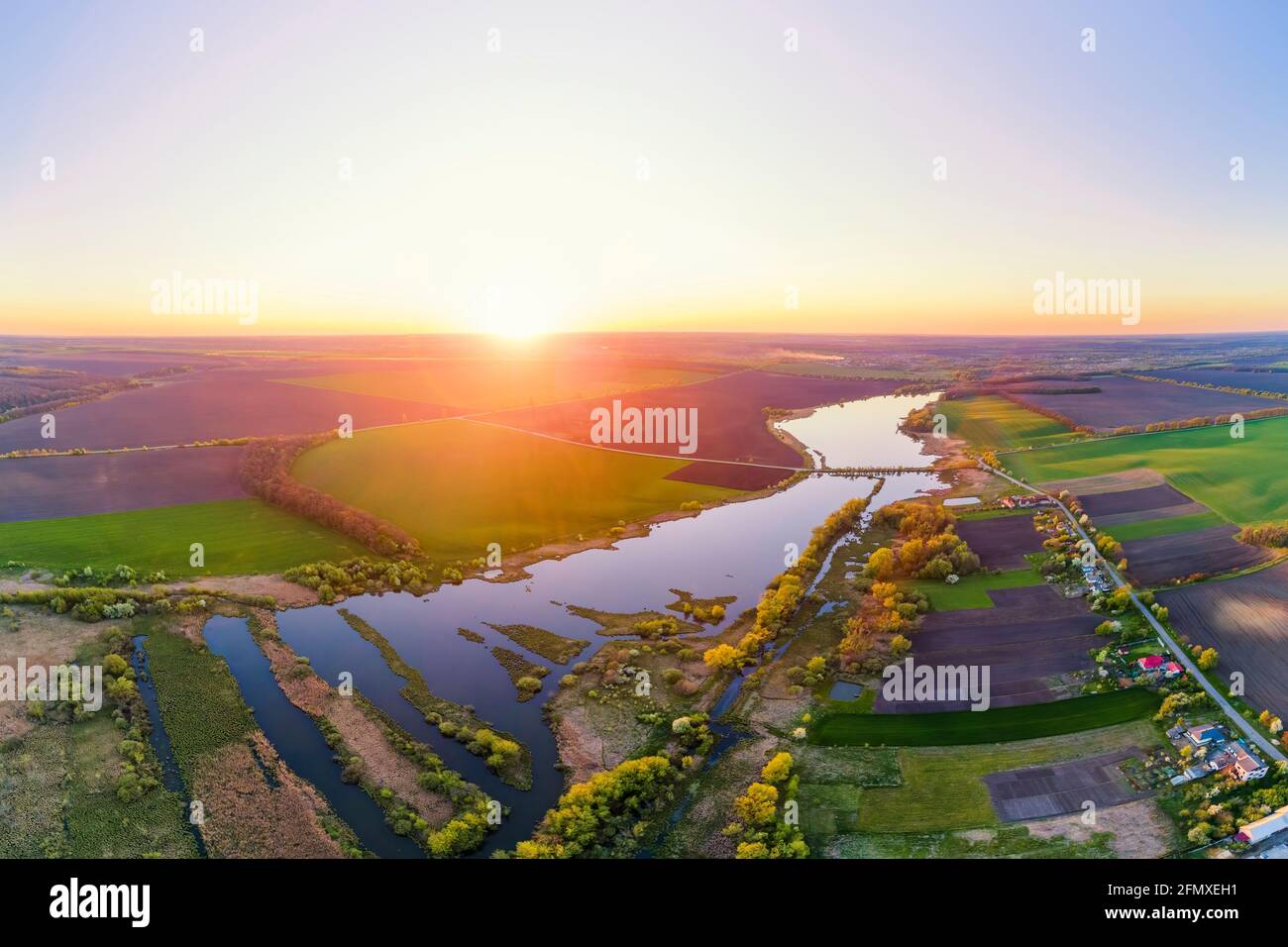 Aerial photo of sunset countryside landscape with lake, green fields ...