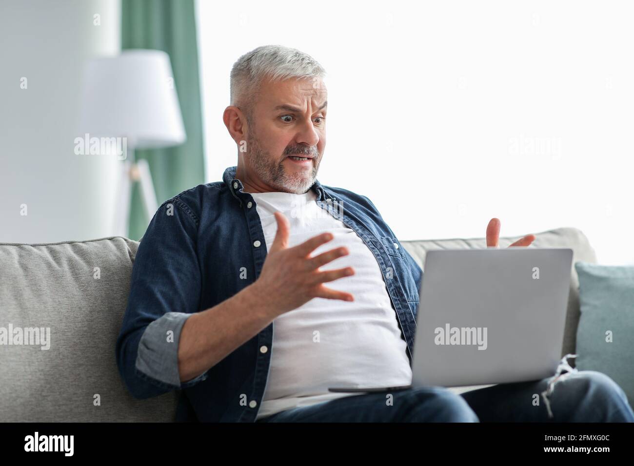 Shocked senior man looking at laptop screen Stock Photo - Alamy