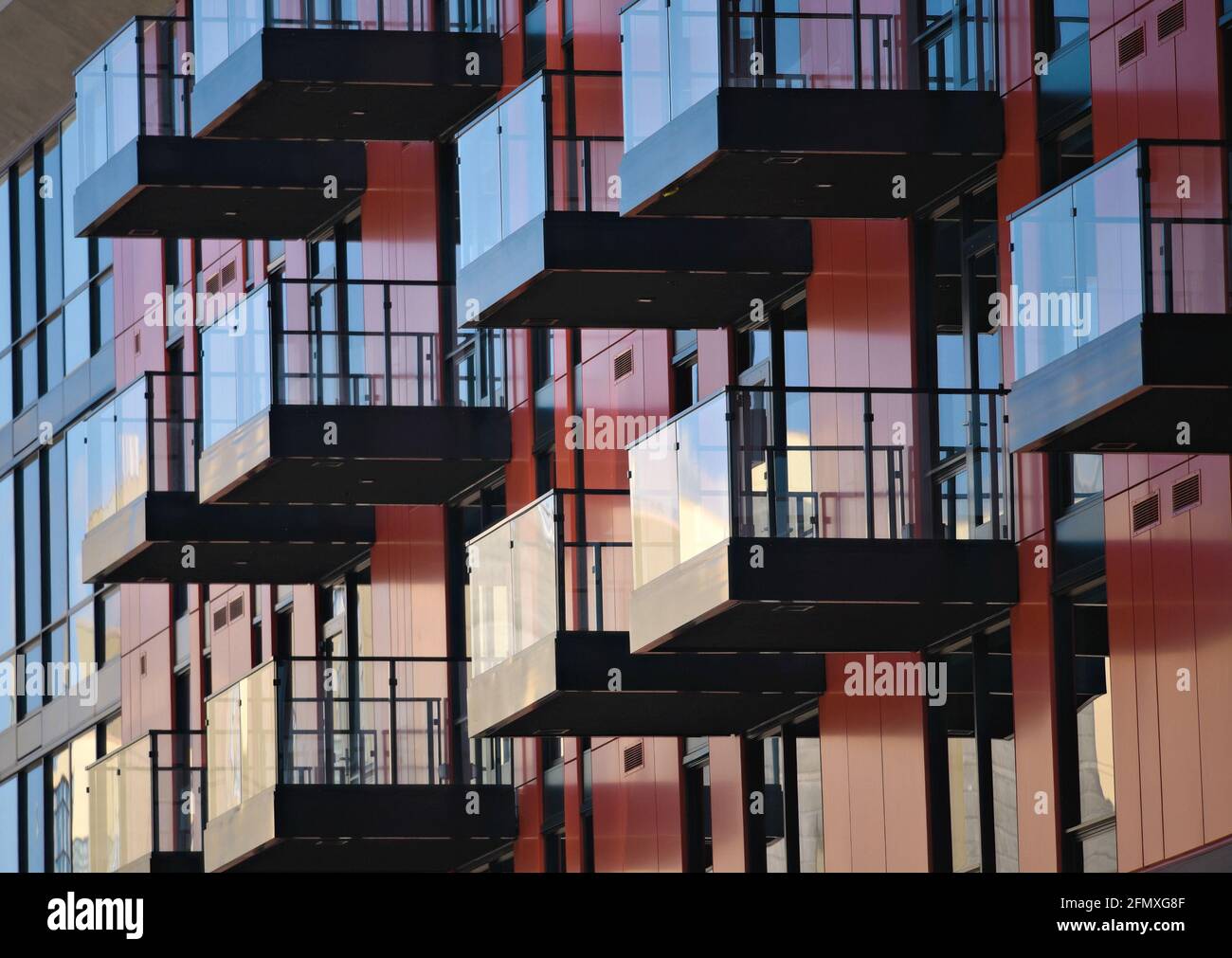 High-rise condominiums complex facade with a red and black cladding and ...