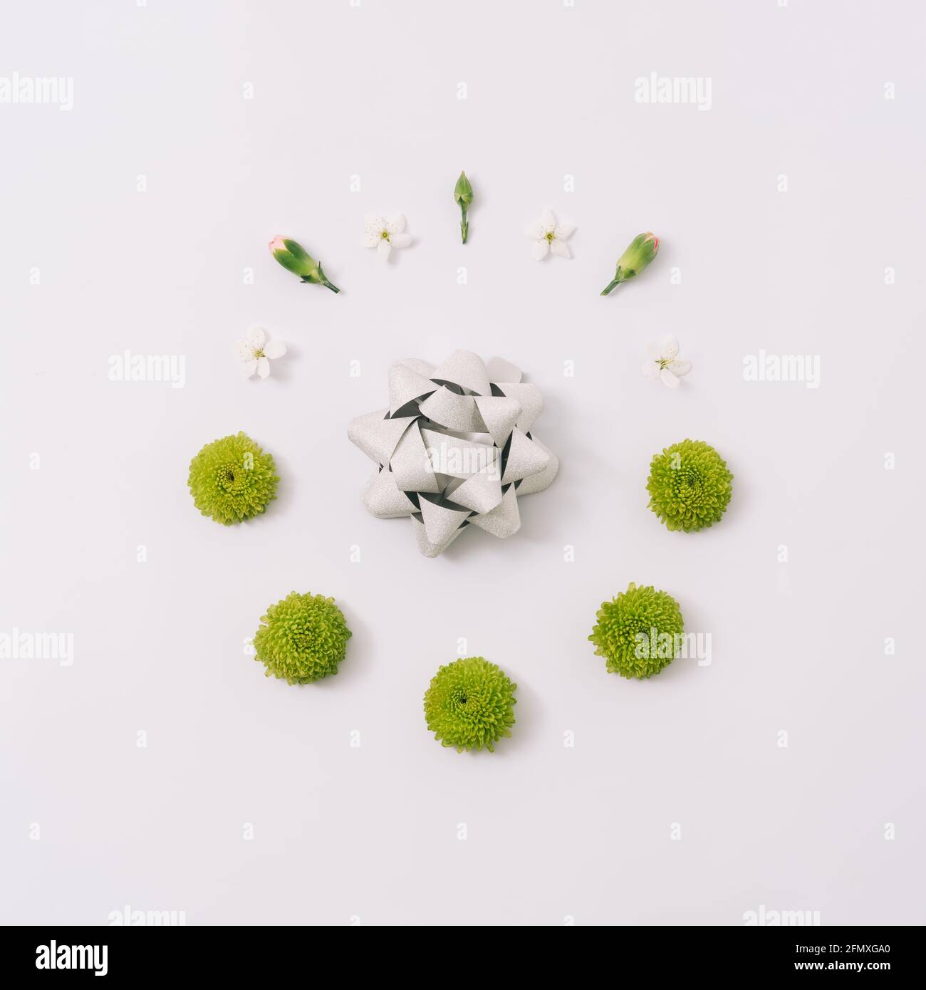 A background of fresh spring flowers in a circle and a silver bow ...