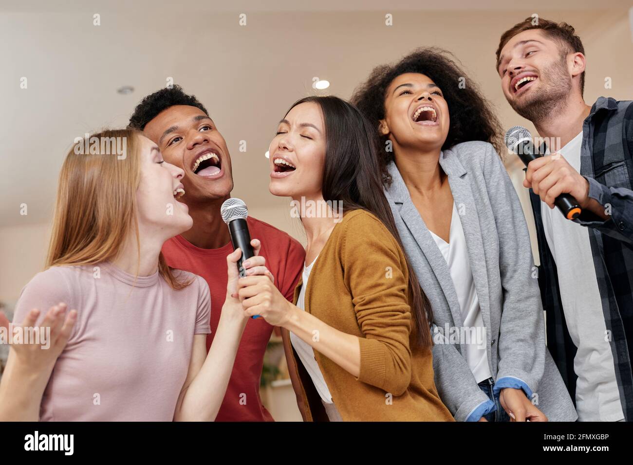Singing for everyone. Cheerful multicultured friends singing with ...