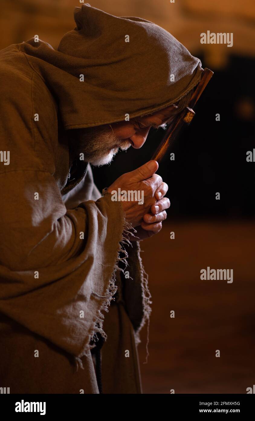Medieval monk with cross in prayer Stock Photo - Alamy