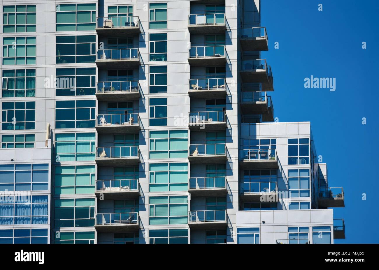 Residential condominiums complex facade with symmetrical white concrete ...