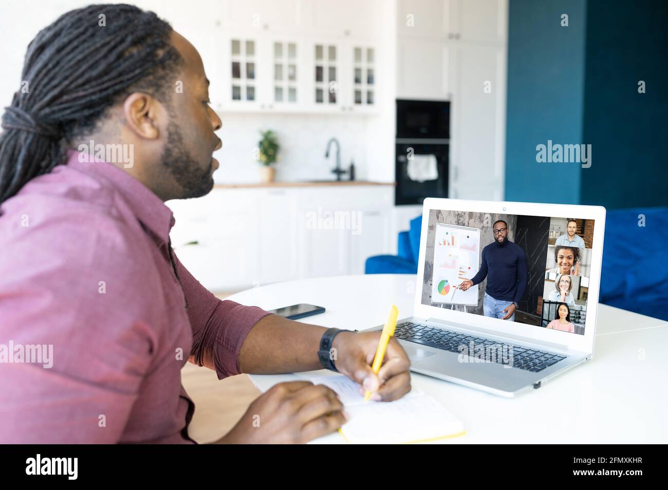 Focused African-American male student with locks hairstyle using laptop ...