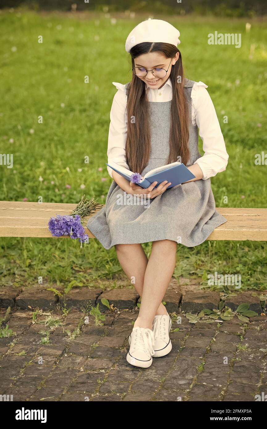 Reading development. Little child read book on park bench. Child ...