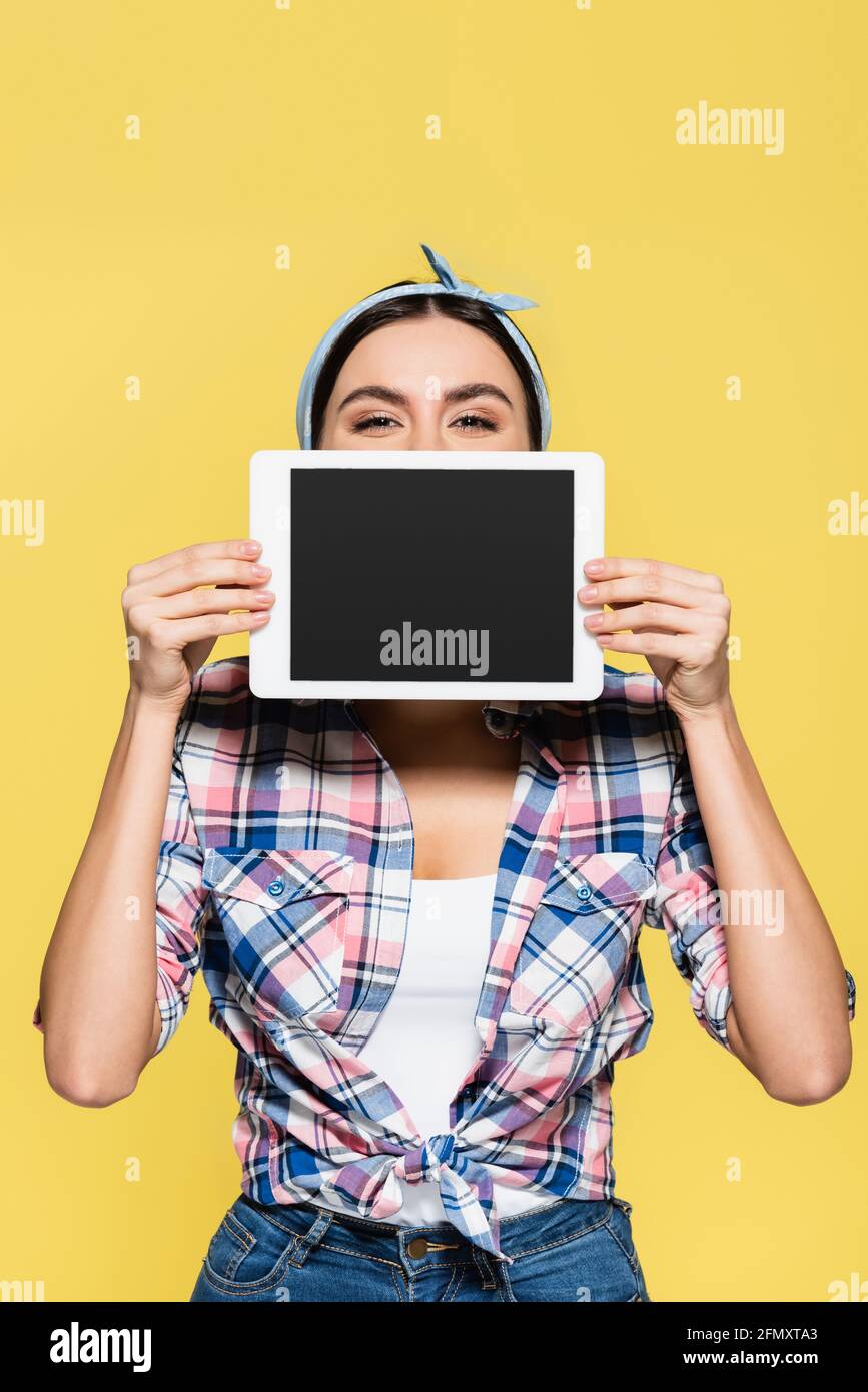 Housewife holding digital tablet near face isolated on yellow Stock ...
