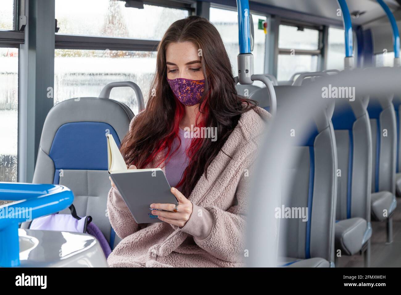 Young woman reading book in the bus Stock Photo - Alamy