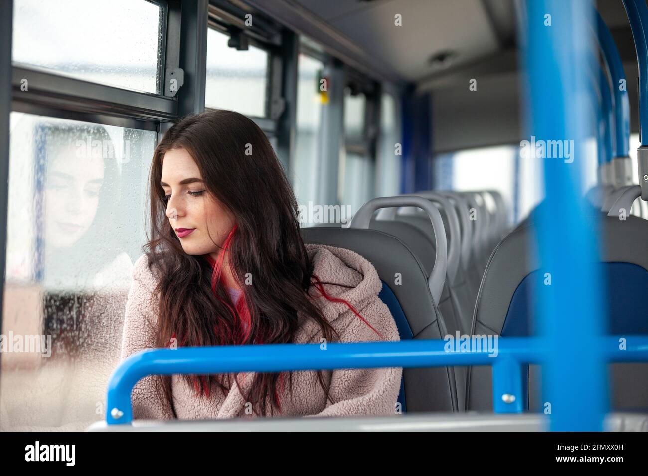 A woman travelling on a bus with her eyes closed Stock Photo - Alamy