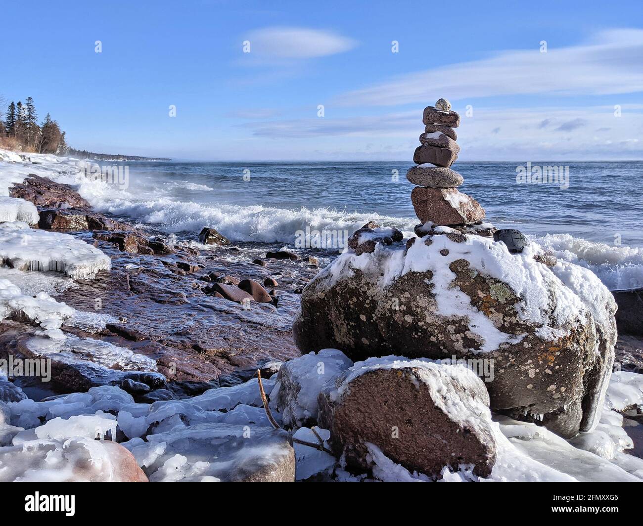 A rock cairn punctuates the boulder-strewn, icebound shore of Lake ...