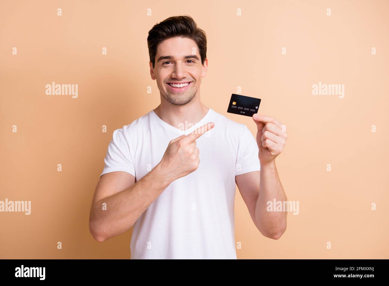 Portrait of handsome positive cheerful person indicate finger debit ...