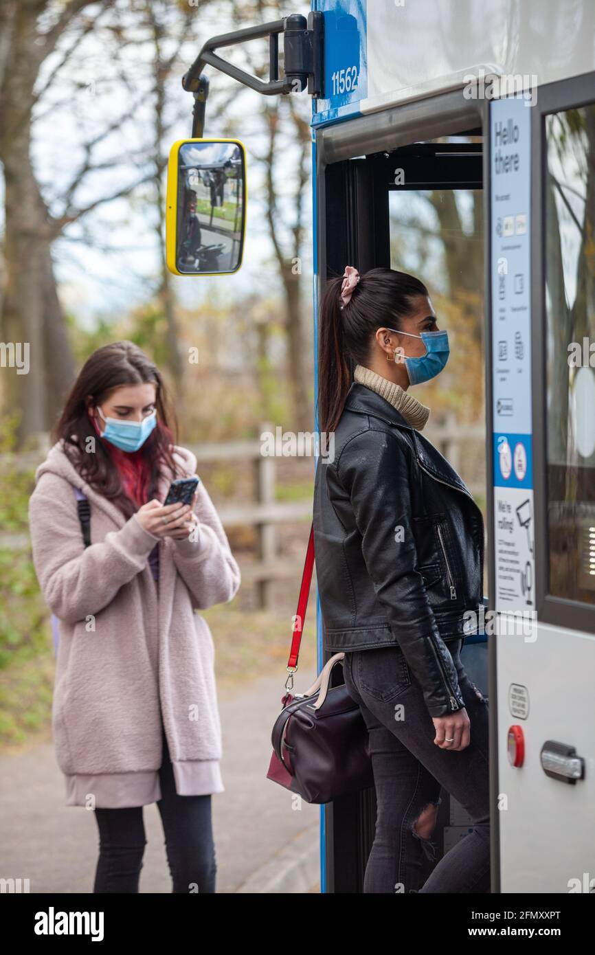 Two young women about to board a bus during the day Stock Photo - Alamy