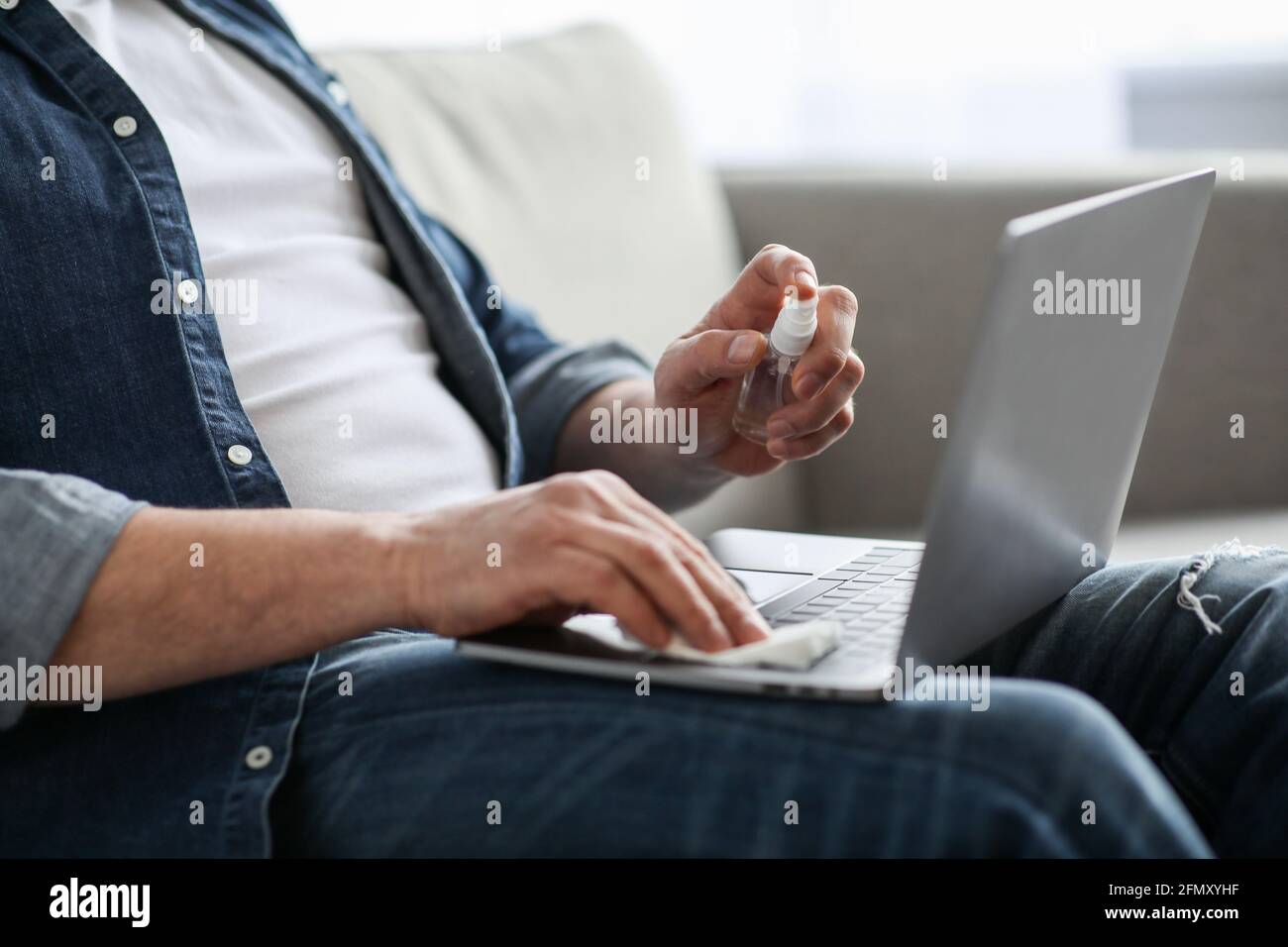 Male hands using disinfectant spray for cleaning laptop, cropped Stock ...
