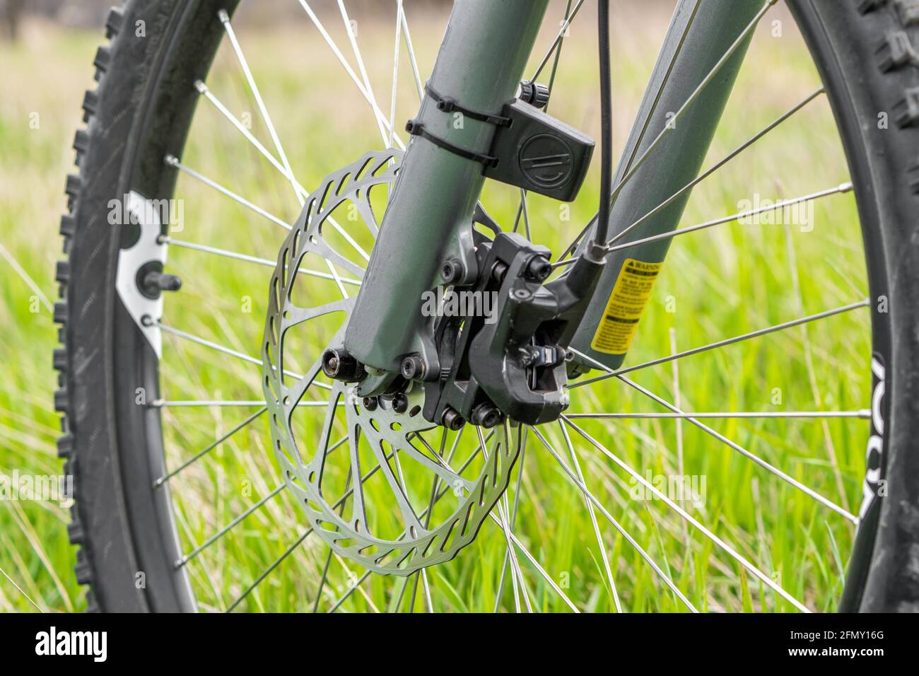 Mountain bike front wheel with large hydraulic brake rotor. Against a ...