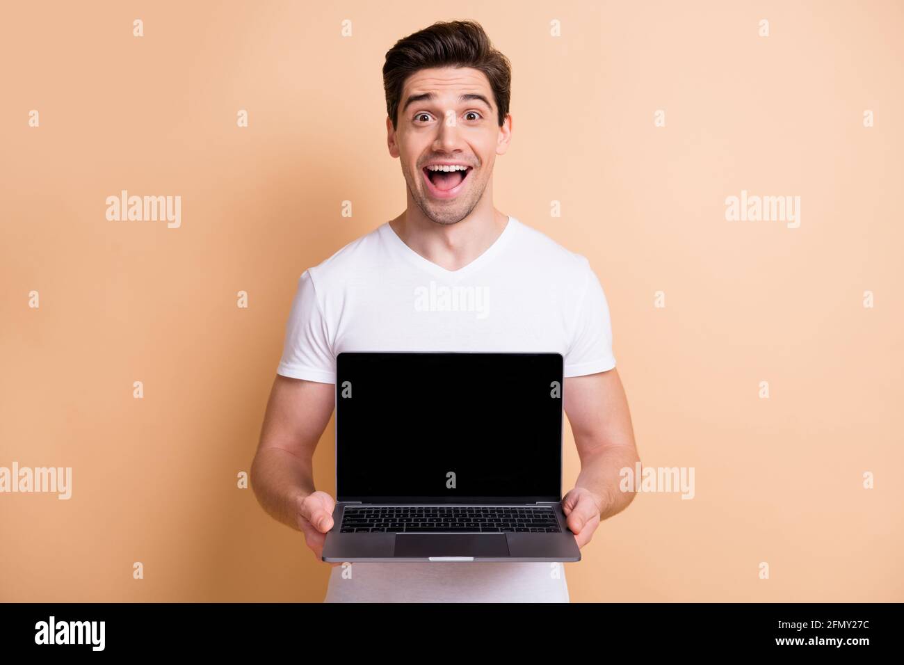 Photo of impressed handsome person open mouth hold netbook showing ...