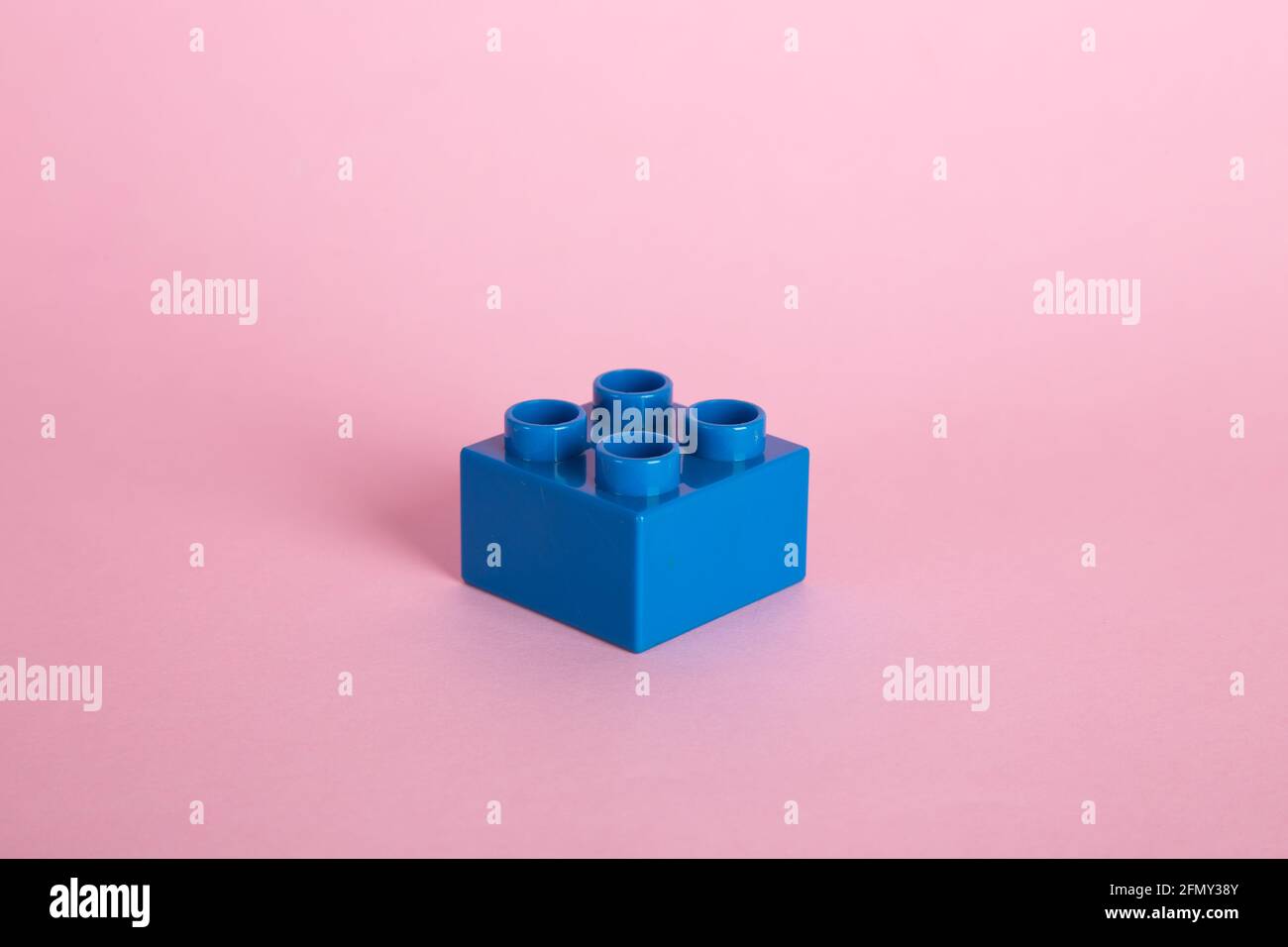 Plastic building blocks on pink background Stock Photo - Alamy