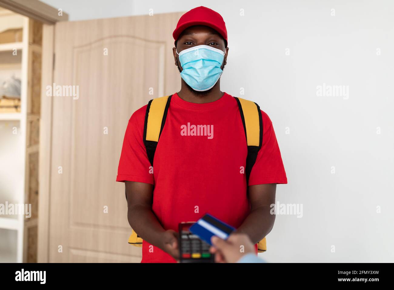 Portrait of black man holding POS machine for payment Stock Photo - Alamy