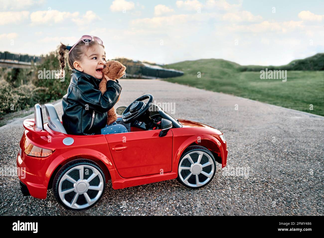 A girl riding a toy car Stock Photo - Alamy