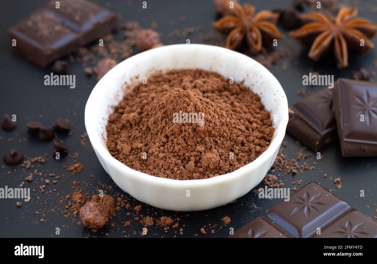 Chocolate chunks, cocoa powder and spice on dark slate table, cooking ...