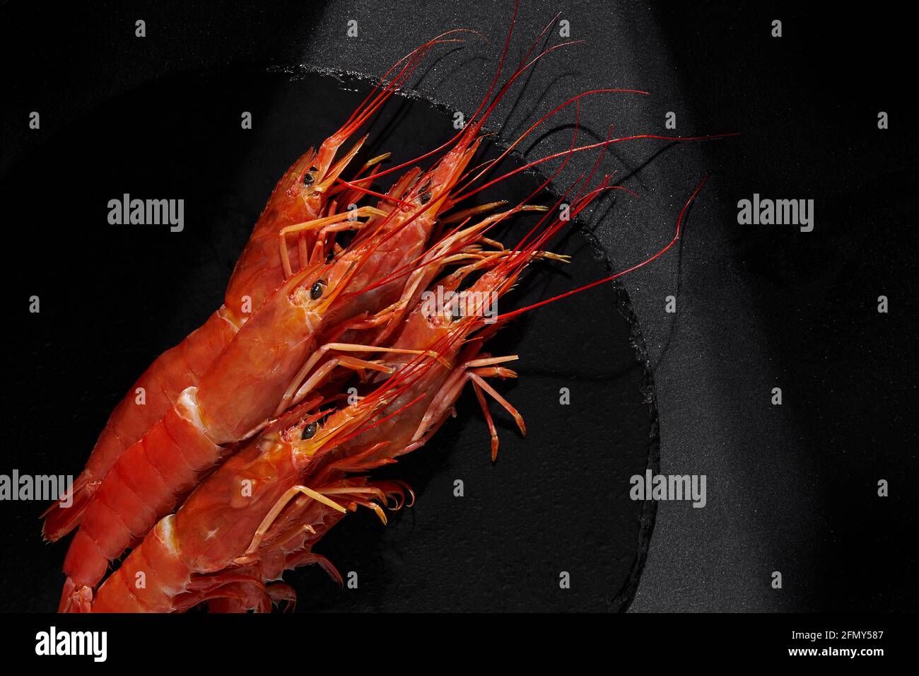 Whole red prawns on black background with spotlight effect Stock Photo ...