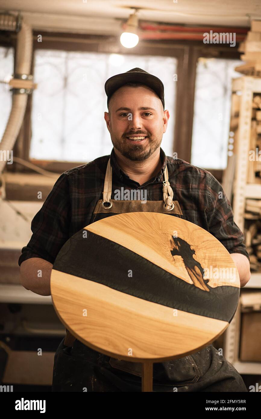 Carpenter showing table at his production in carpentry workplace Stock ...