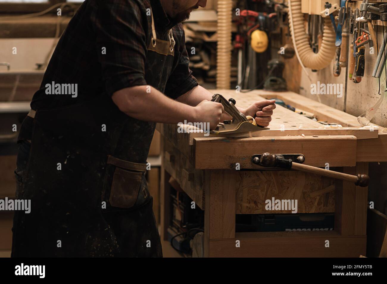 Man carpenter using hand planer in his workshop Stock Photo - Alamy