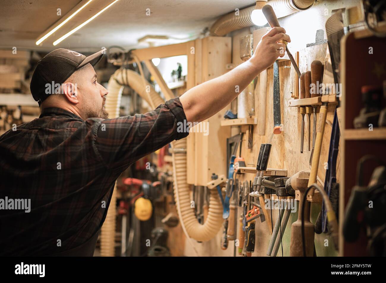 Male joiner chooses tools for work in workshop Stock Photo - Alamy