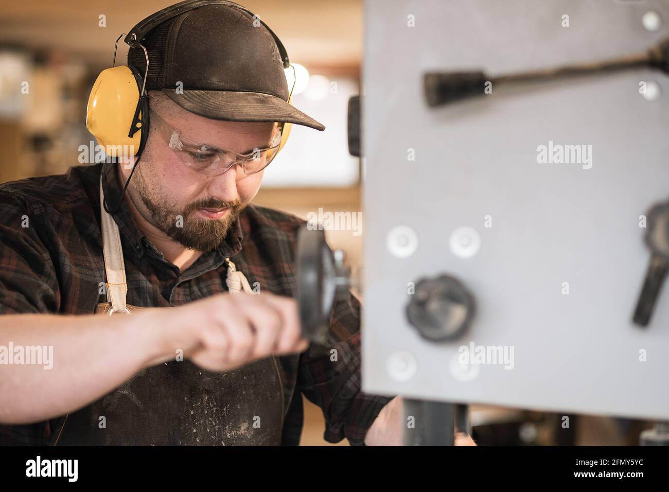 protective ear muffs on the carpenter and goggles Stock Photo - Alamy