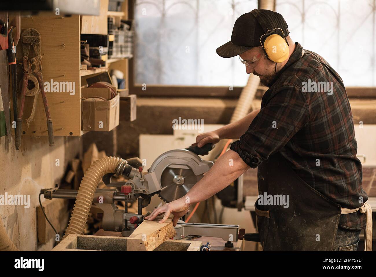 Carpenter cutting wood on circular saw in workshop place Stock Photo ...