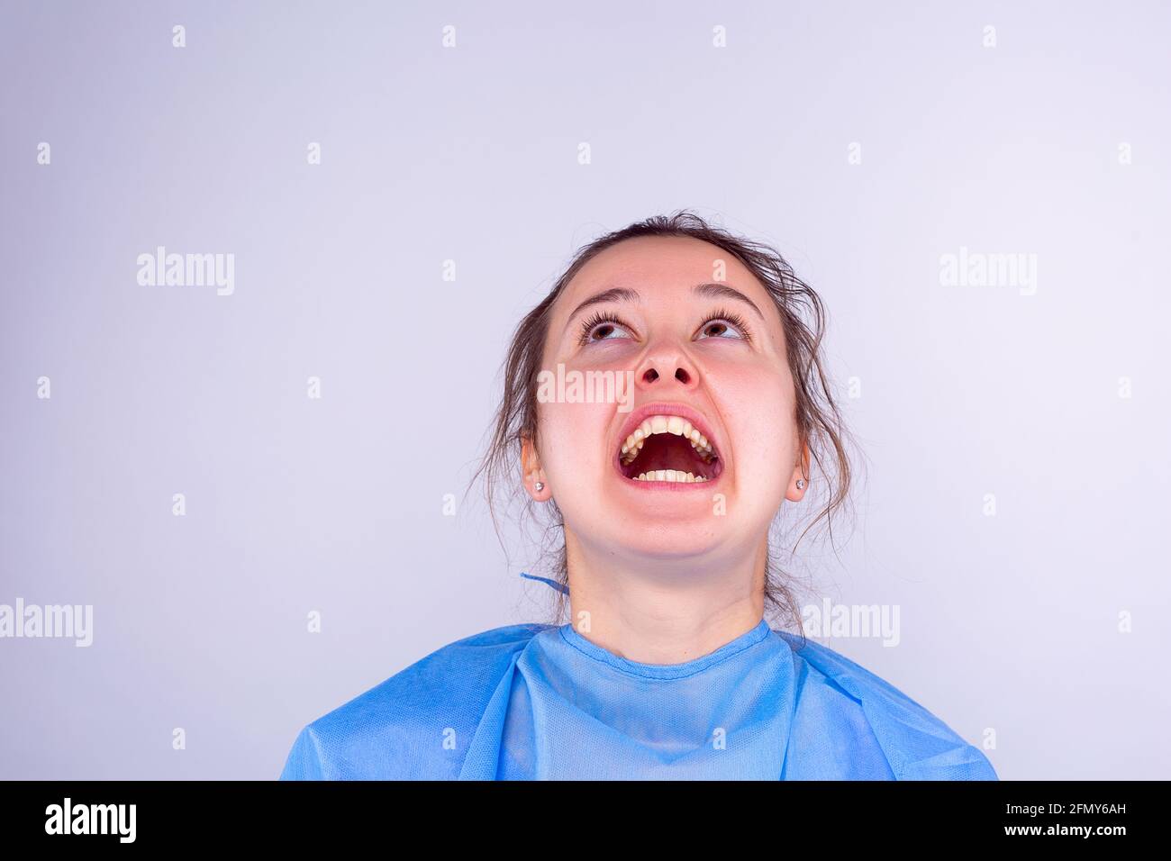 Portrait of a frustrated, upset, angry, screaming young woman doctor ...