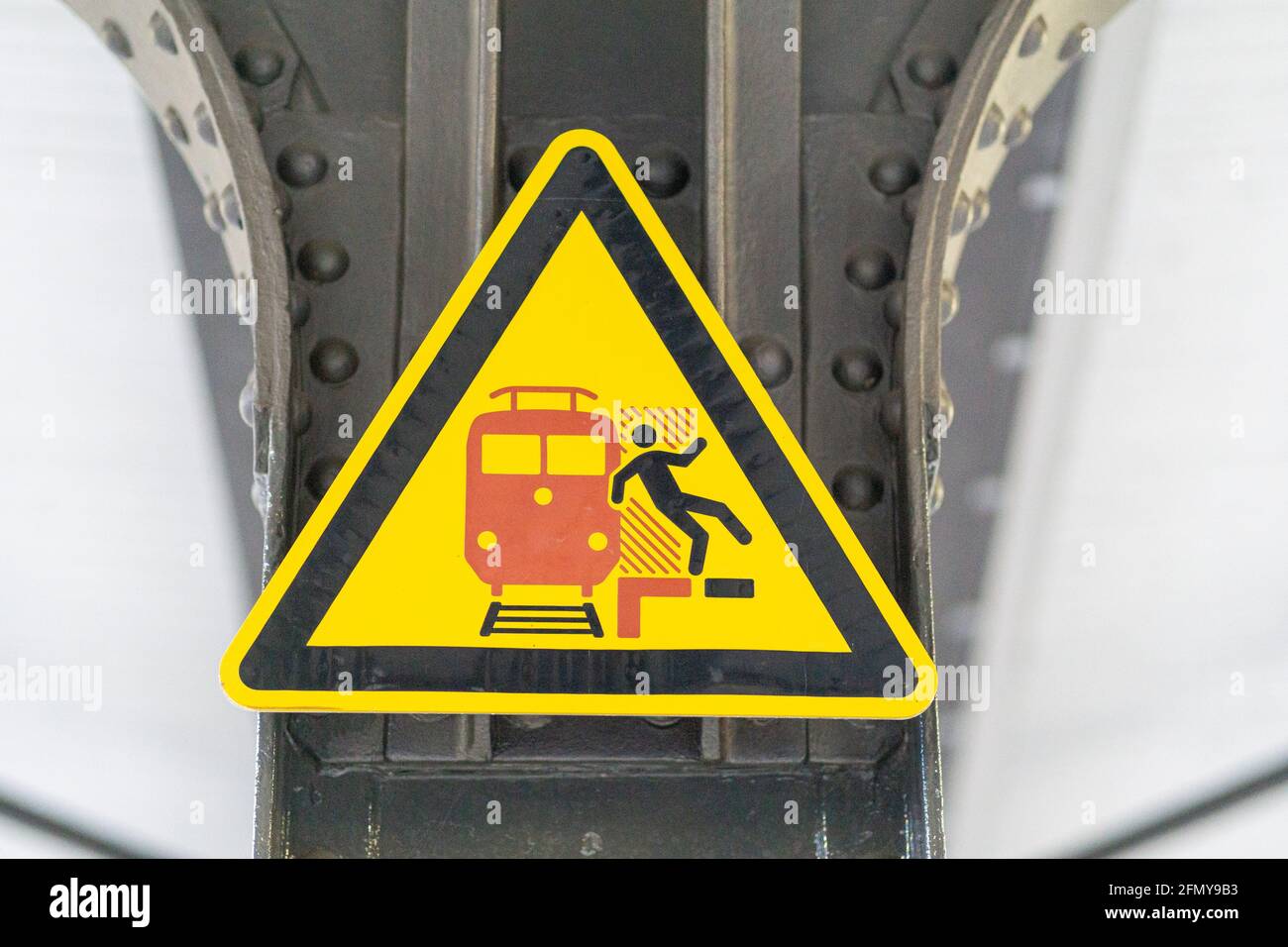 Closeup of a yellow warning sign in the train station Stock Photo - Alamy