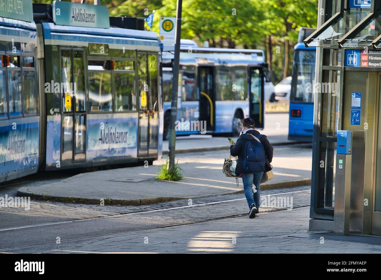 MUNICH, GERMANY - May 11, 2021: One person walks to the stop with buses ...