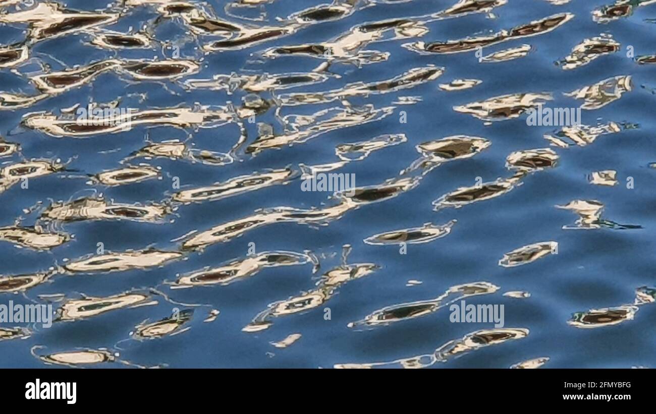 Patterns and reflections in harbour water Stock Photo - Alamy