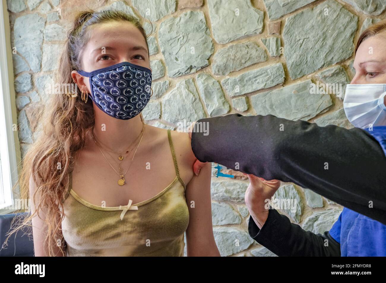 A young woman receives her Covid-19 vaccination at a vaccination clinic ...