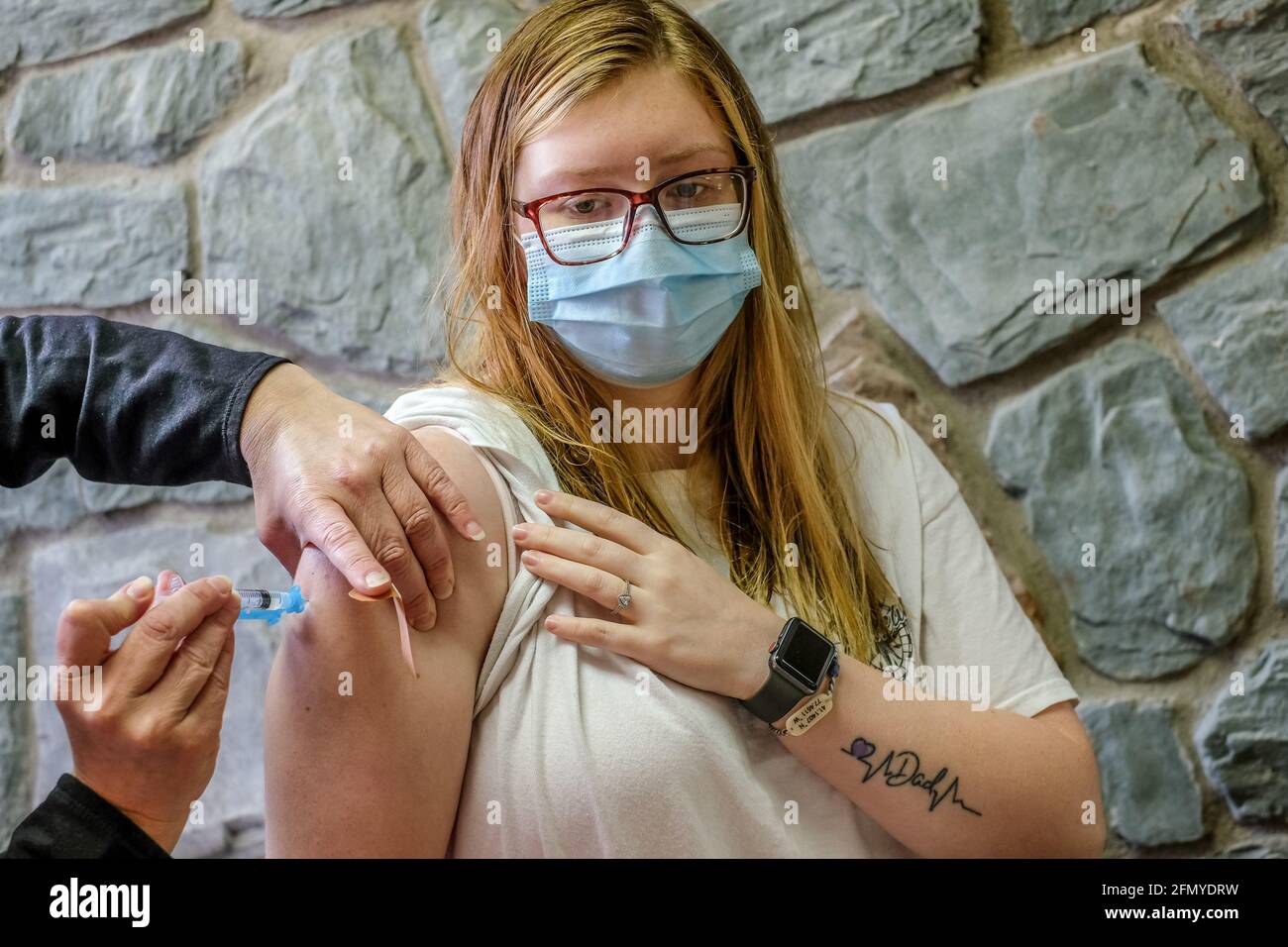 A young woman receives her Covid-19 vaccination at a vaccination clinic ...