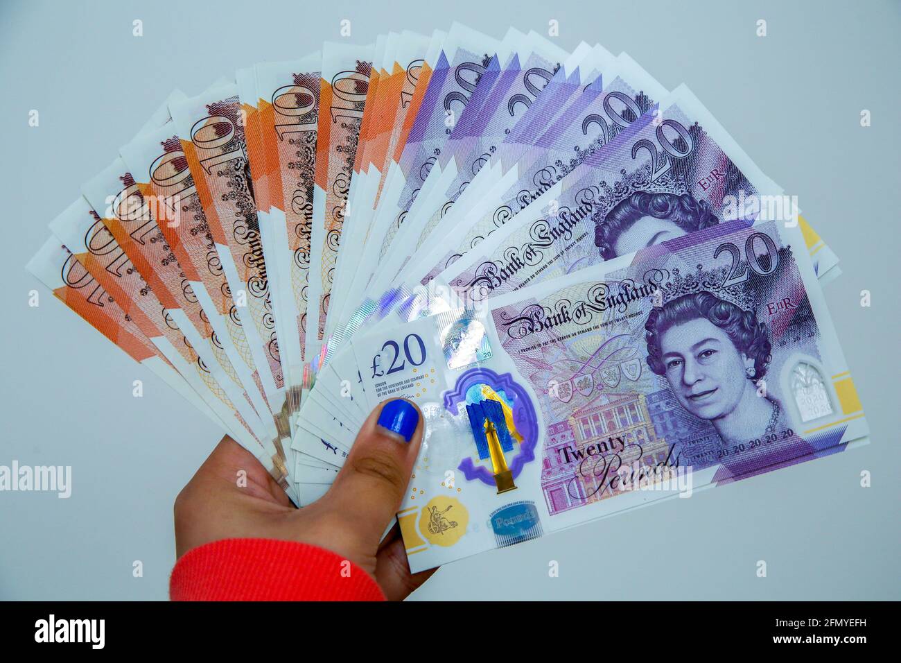 In this photo illustration, a woman holds a collection of British ...