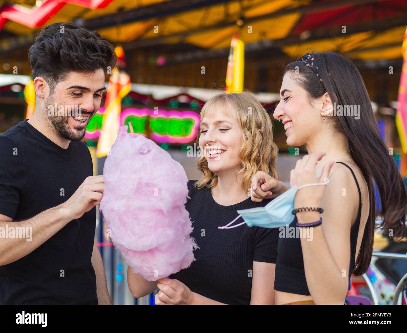 Friends eating candy cotton together in the amusement park Stock Photo ...