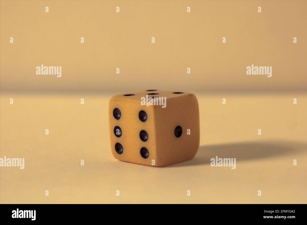 Extreme closeup macro of a dice with number 5 against plain background ...