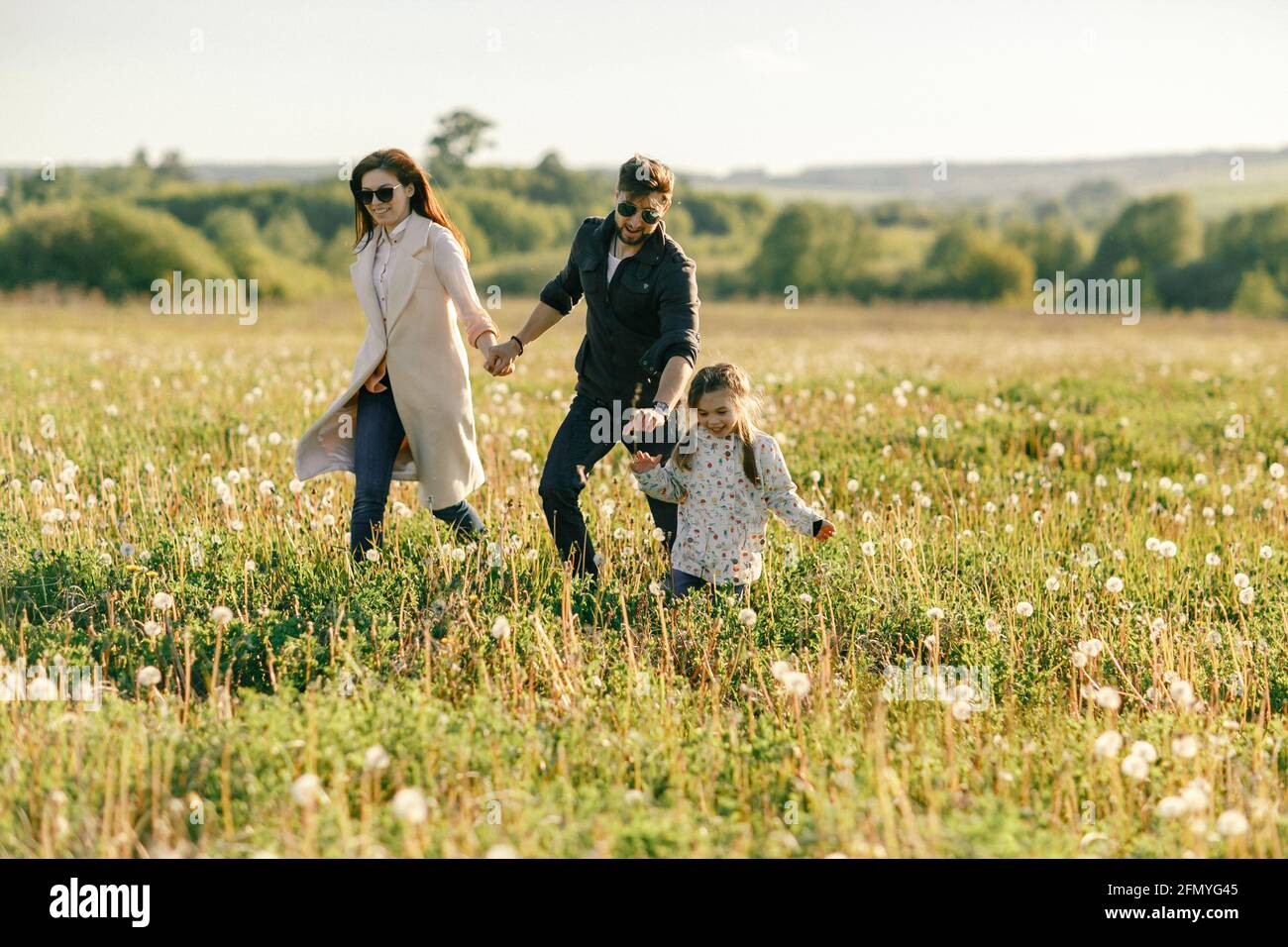 Happy family father, mother and child daughter on nature at sunset ...