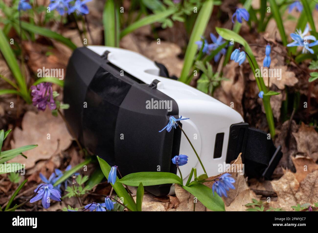 3D Virtual reality headset glasses in spring blue wild flowers. VR tech ...