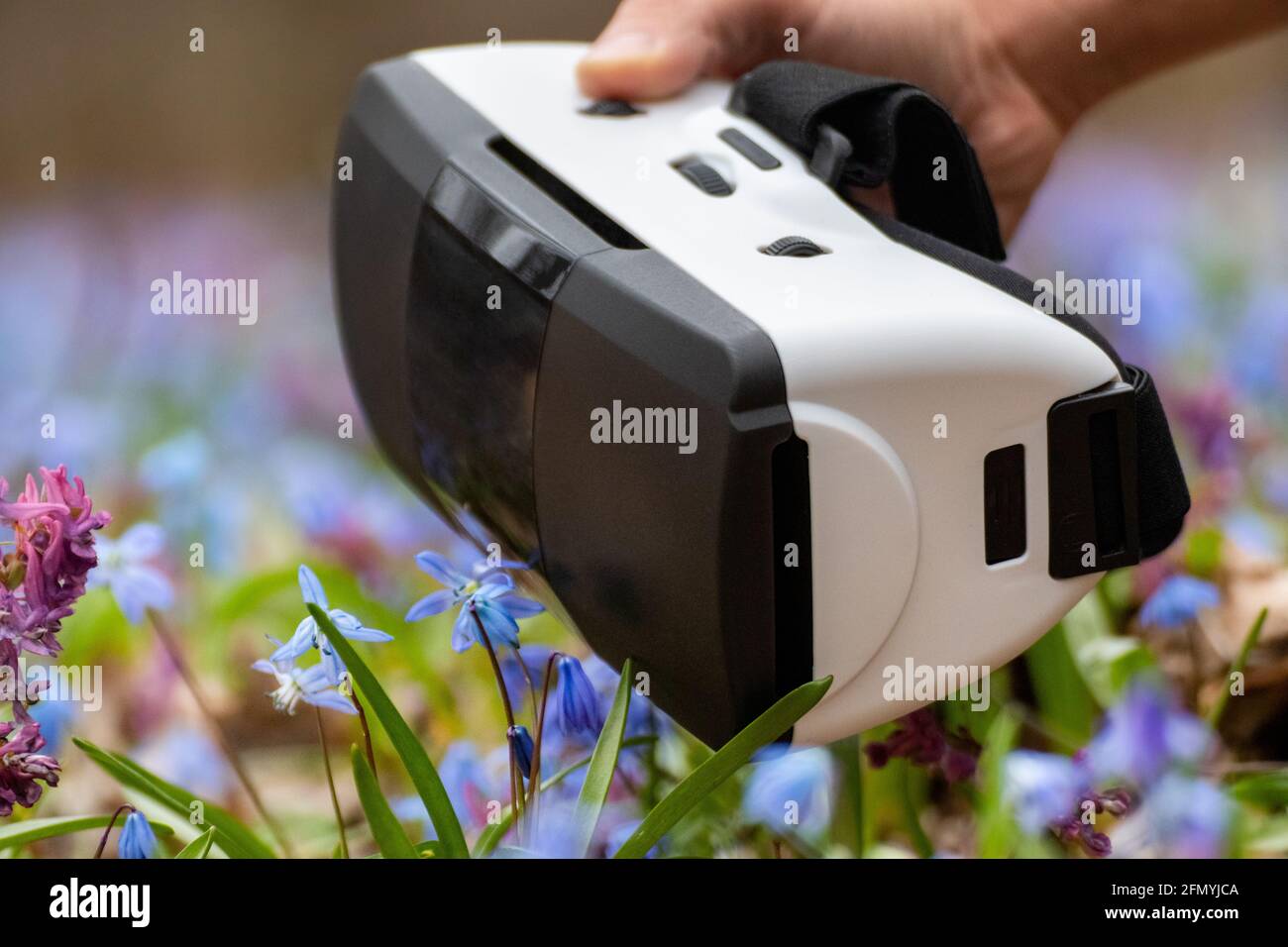 Hand holding 3D Virtual reality headset glasses in spring blue wild ...