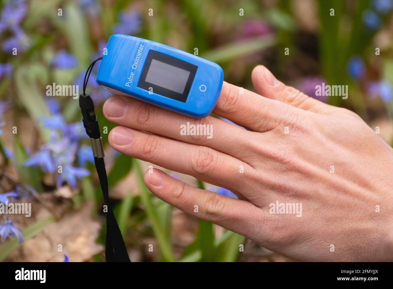 Pulse oximeter on a fingertip. Blue oxygen saturation meter (SPO2 ...