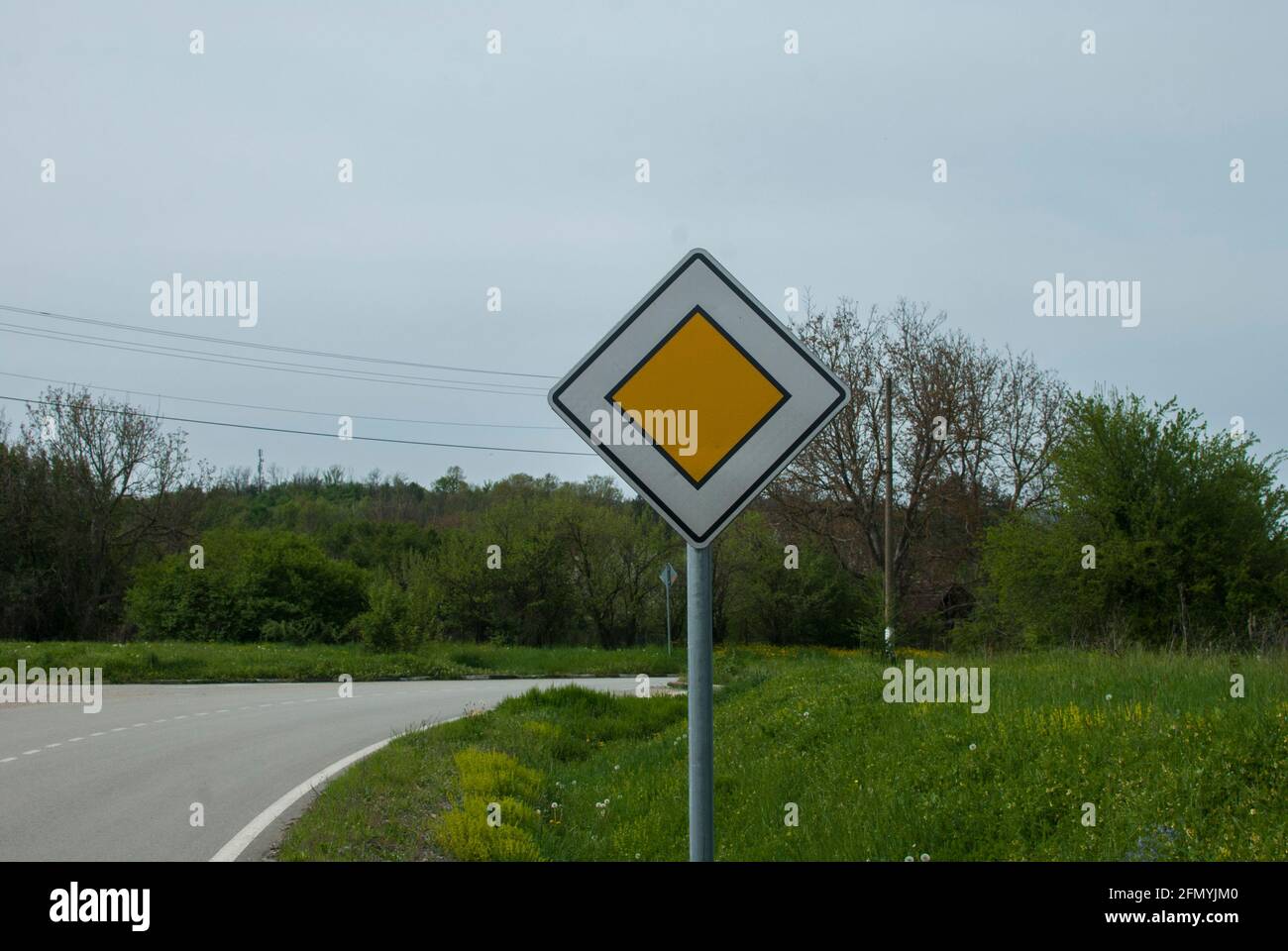 Country road bend and priority road sign closeup Stock Photo - Alamy