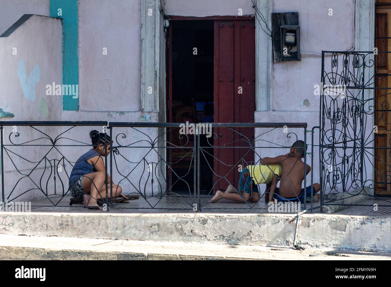 Cuban children playing in a weathered old house porch. Lifestyle in ...