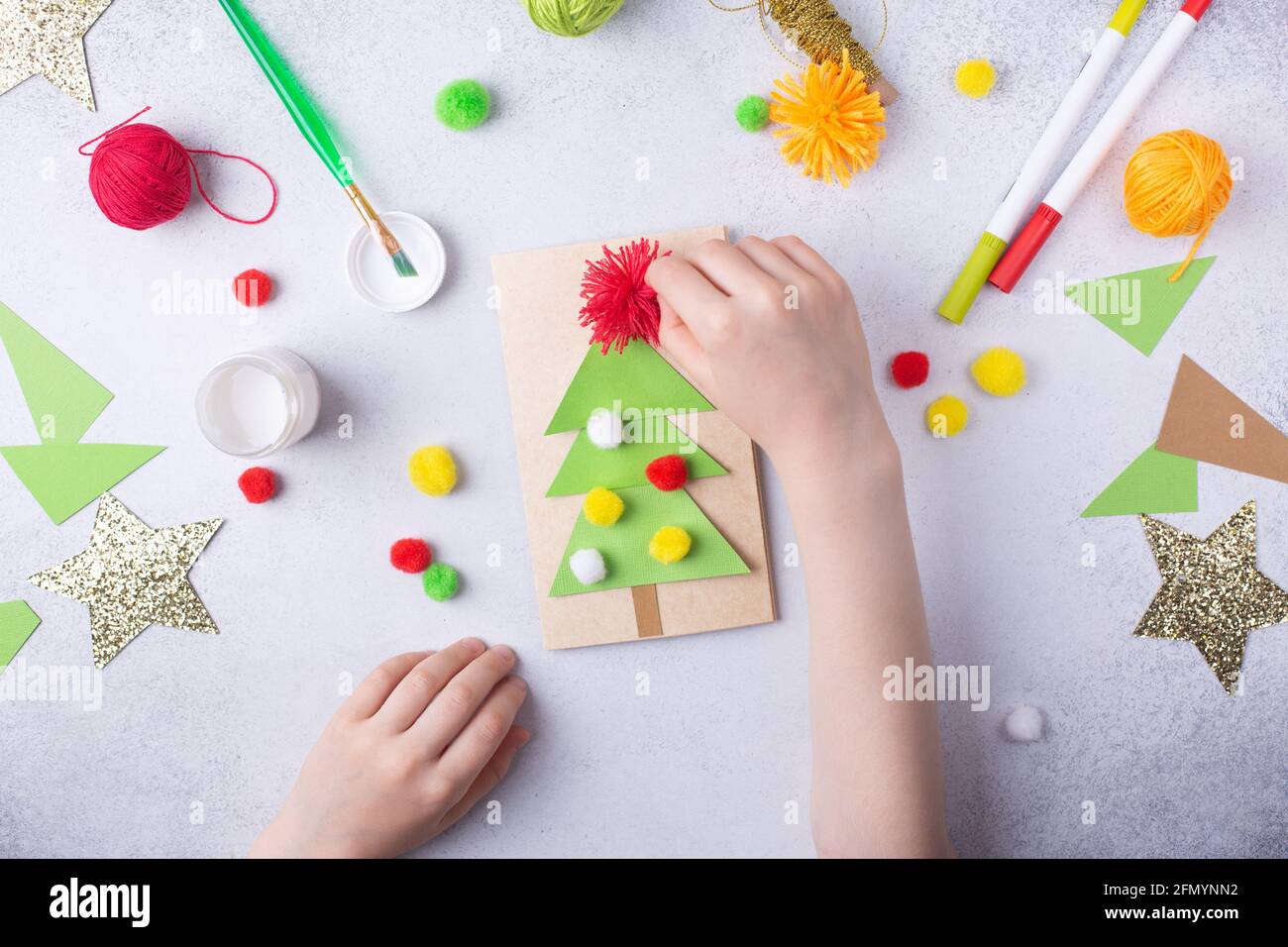The child makes a greeting card Christmas paper collage. Children art ...