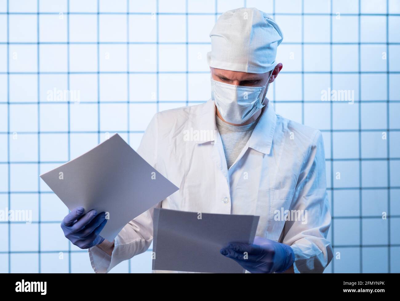 Male Doctor with files on hospital holding clipboard and writing a ...