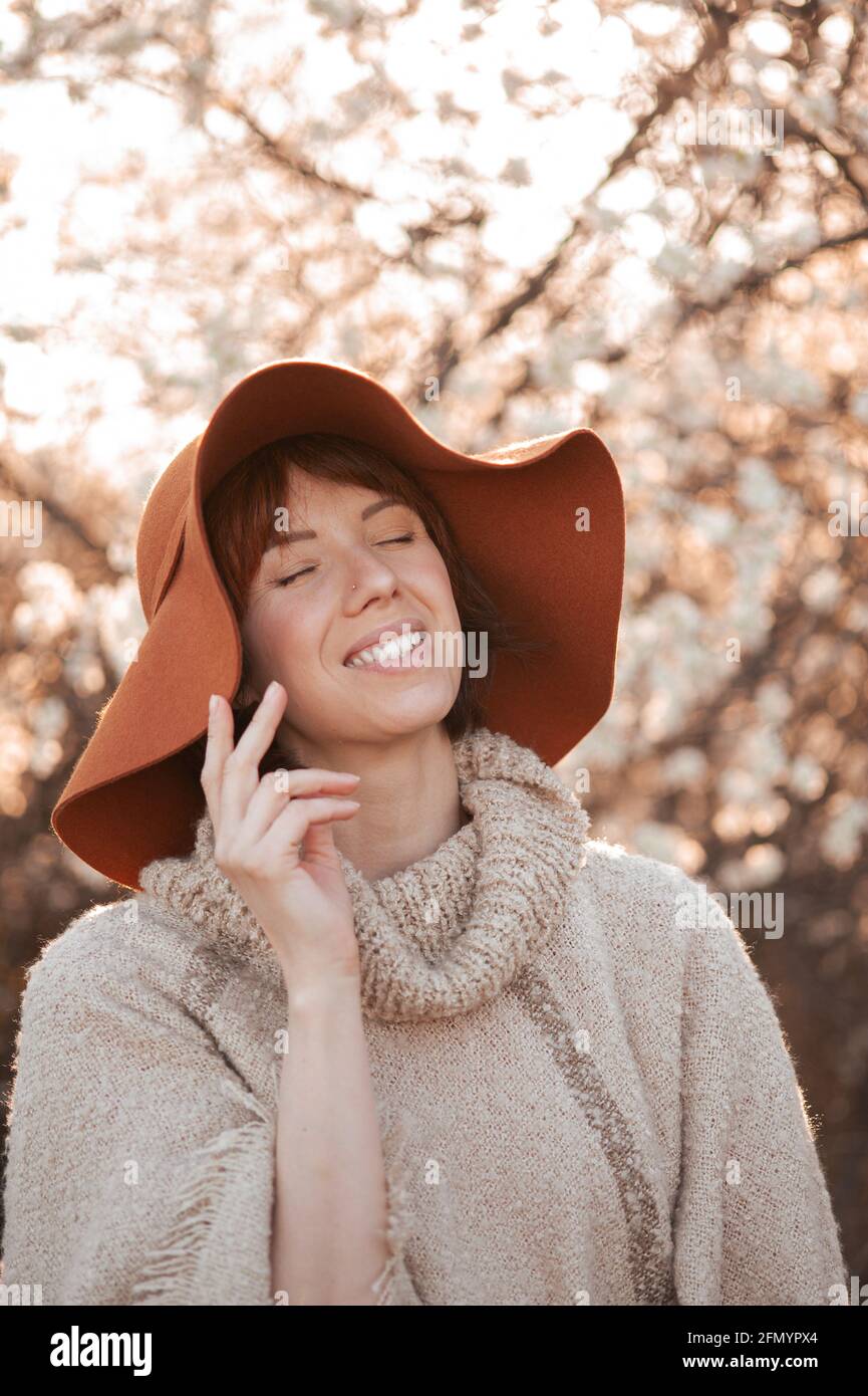 Young smiling girl in a hat on a background of flowering trees Stock ...
