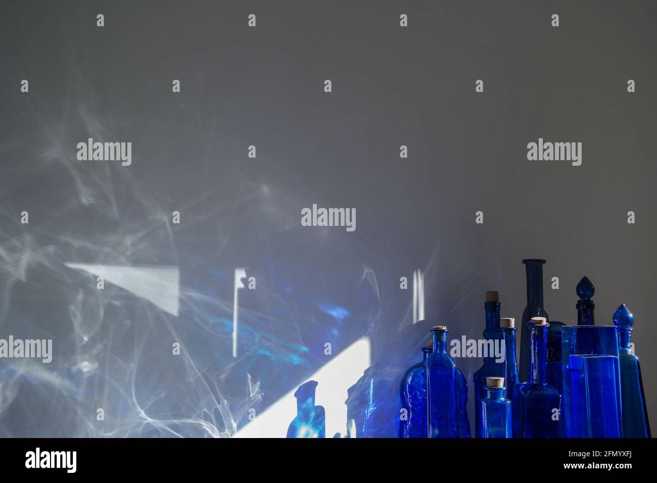 Bunch of blue crystal containers and their reflection on the wall Stock ...
