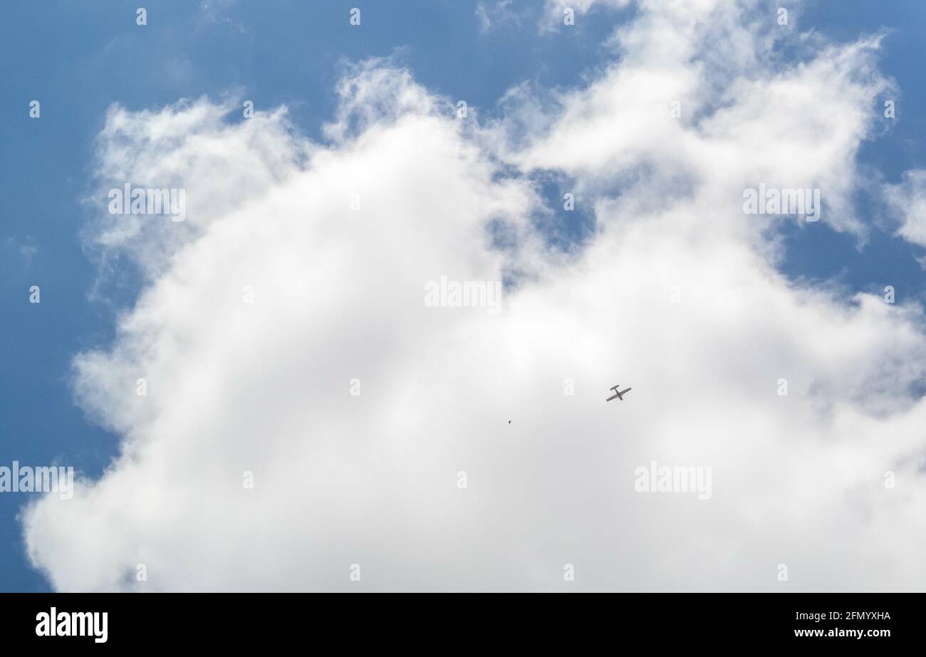 Small plane hovering in the blue cloudy sky Stock Photo - Alamy