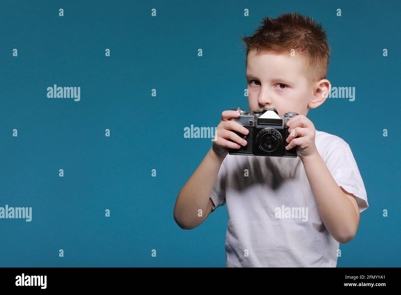 Little boy taking a picture using a retro camera. Child boy with ...